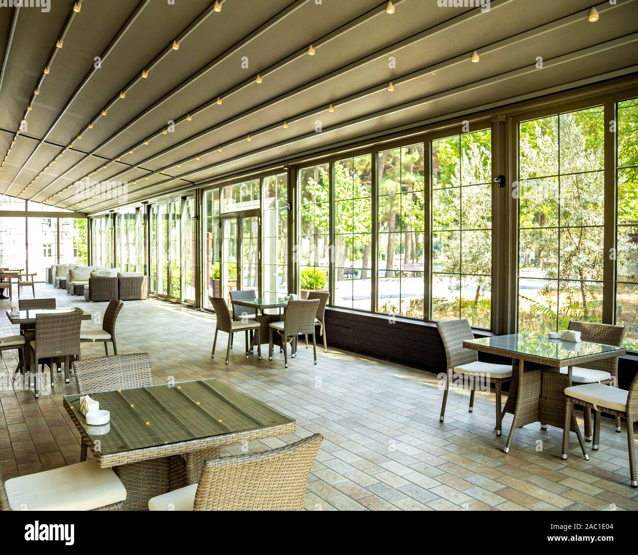 restaurant terrace with glass windows and garden furniture Stock Photo ...