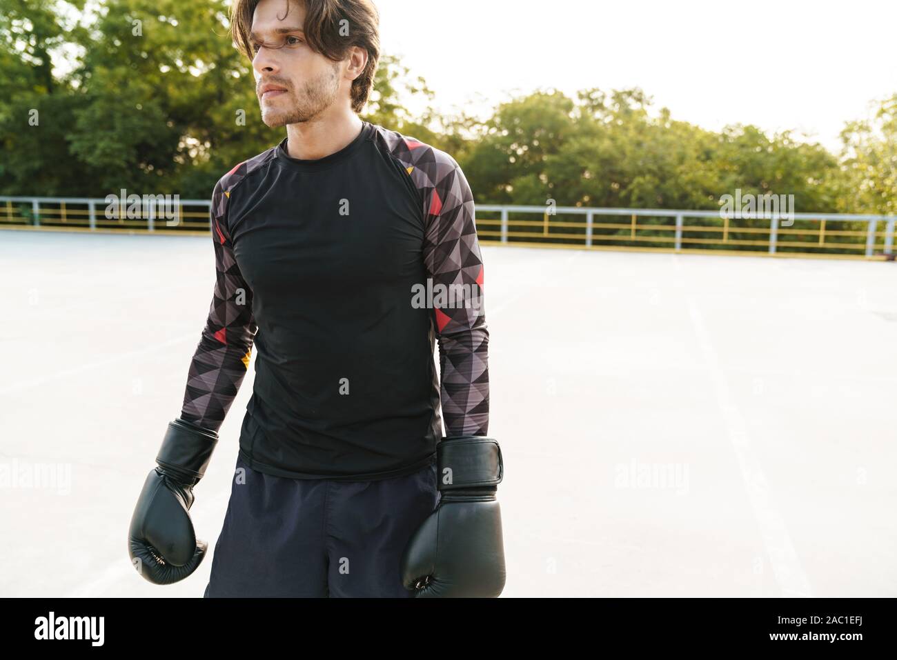 Photo of handsome caucasian man wearing sports clothes standing while ...