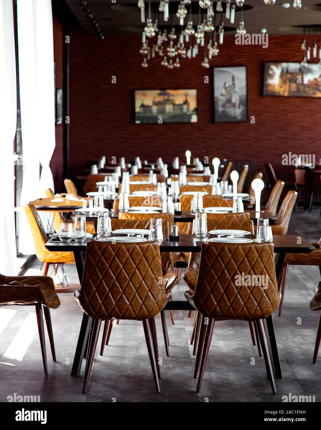 restaurant hall with burgundy wallpaper and brown chairs Stock Photo ...