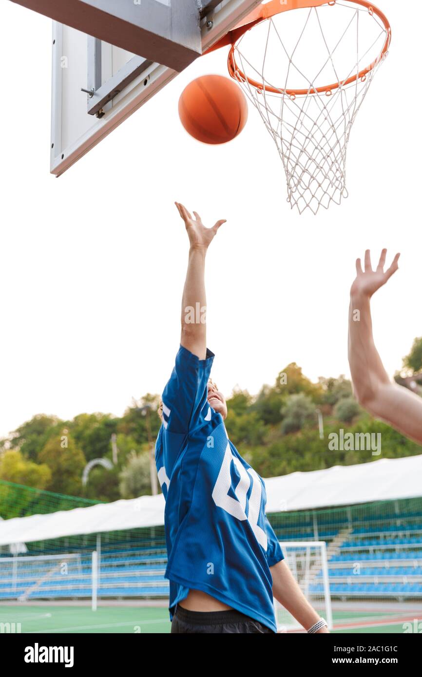 Two basketball pllayers jumping with outstretched hands to the ...