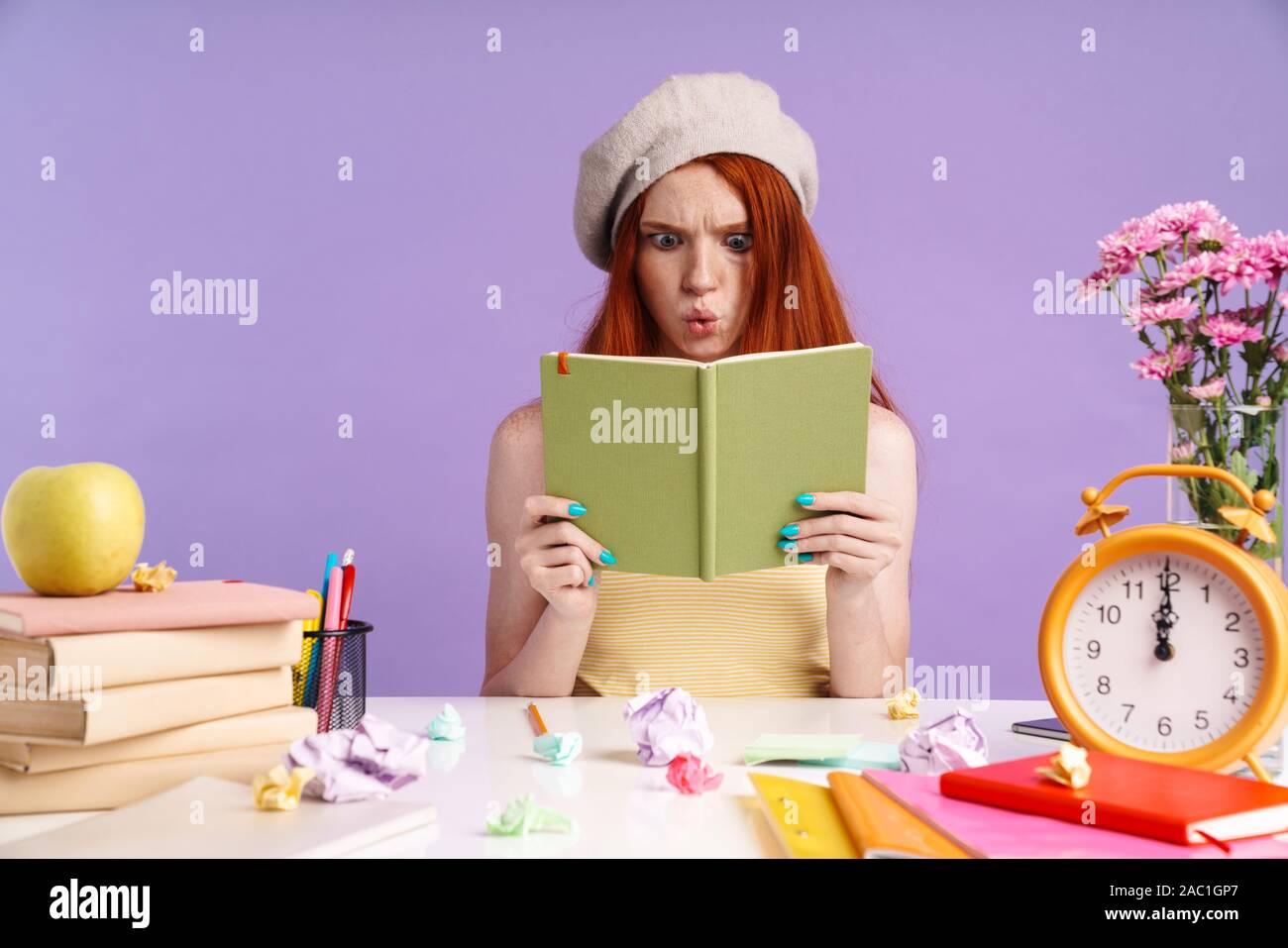 Photo of puzzled student girl holding exercise book while doing ...