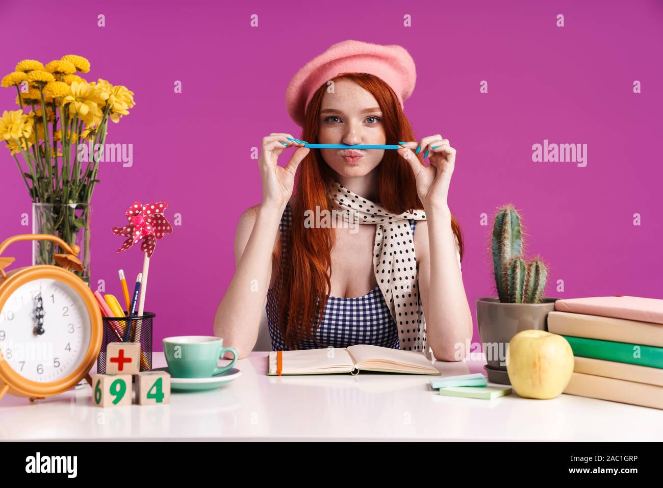 Image of beautiful teenage girl studying with exercise books while ...