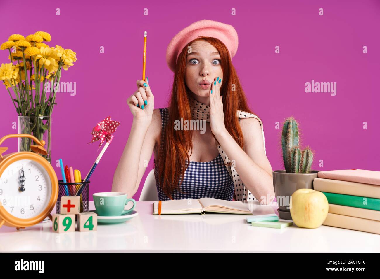 Image of surprised teenage girl studying with exercise books while ...