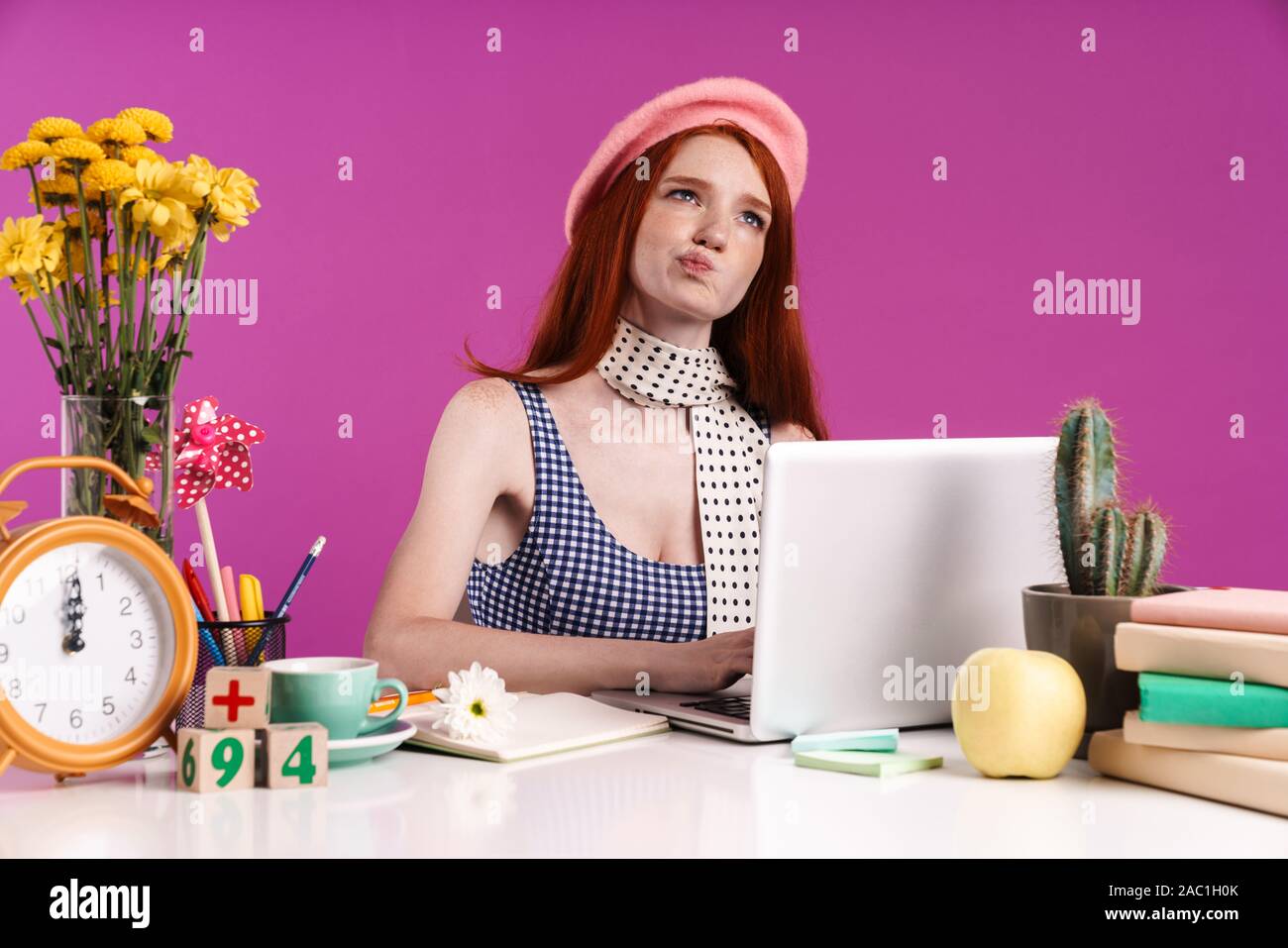 Image of thoughtful teen girl studying on laptop computer while sitting ...