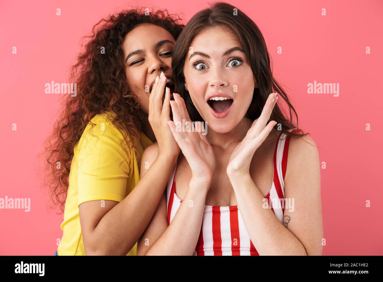 Image of amazing multinational girls wondering while talking secrets or ...