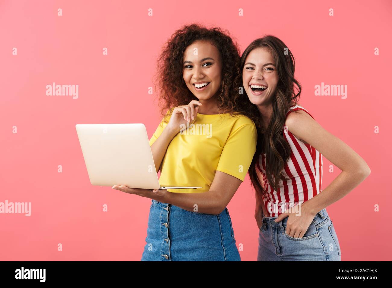 Image of happy multinational girls rejoicing and holding laptop ...