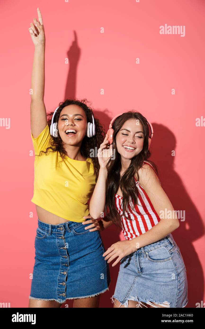Image of optimistic multinational girls rejoicing and listening to ...