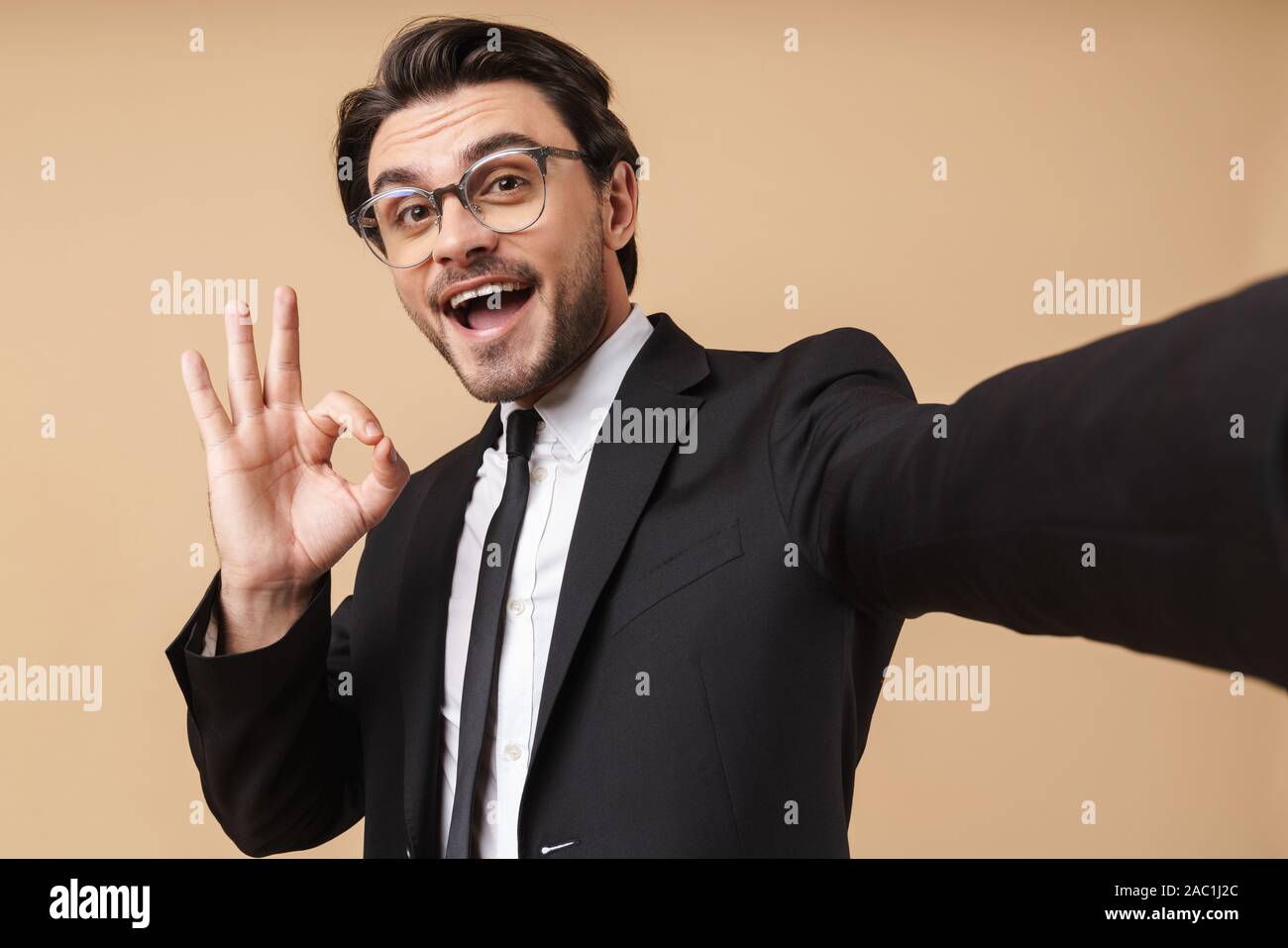 Image of joyful businessman in formal suit showing ok sign while taking ...