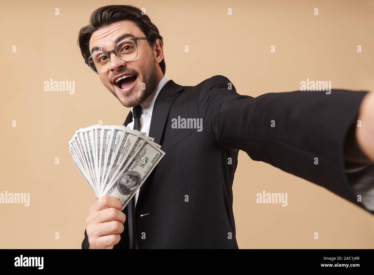 Portrait of a handsome young businessman wearing suit standing isolated ...