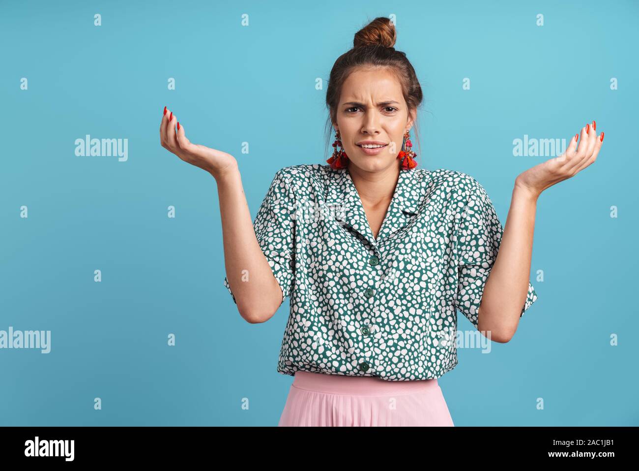 Portrait of a lovely confused young woman wearing shirt and bright ...