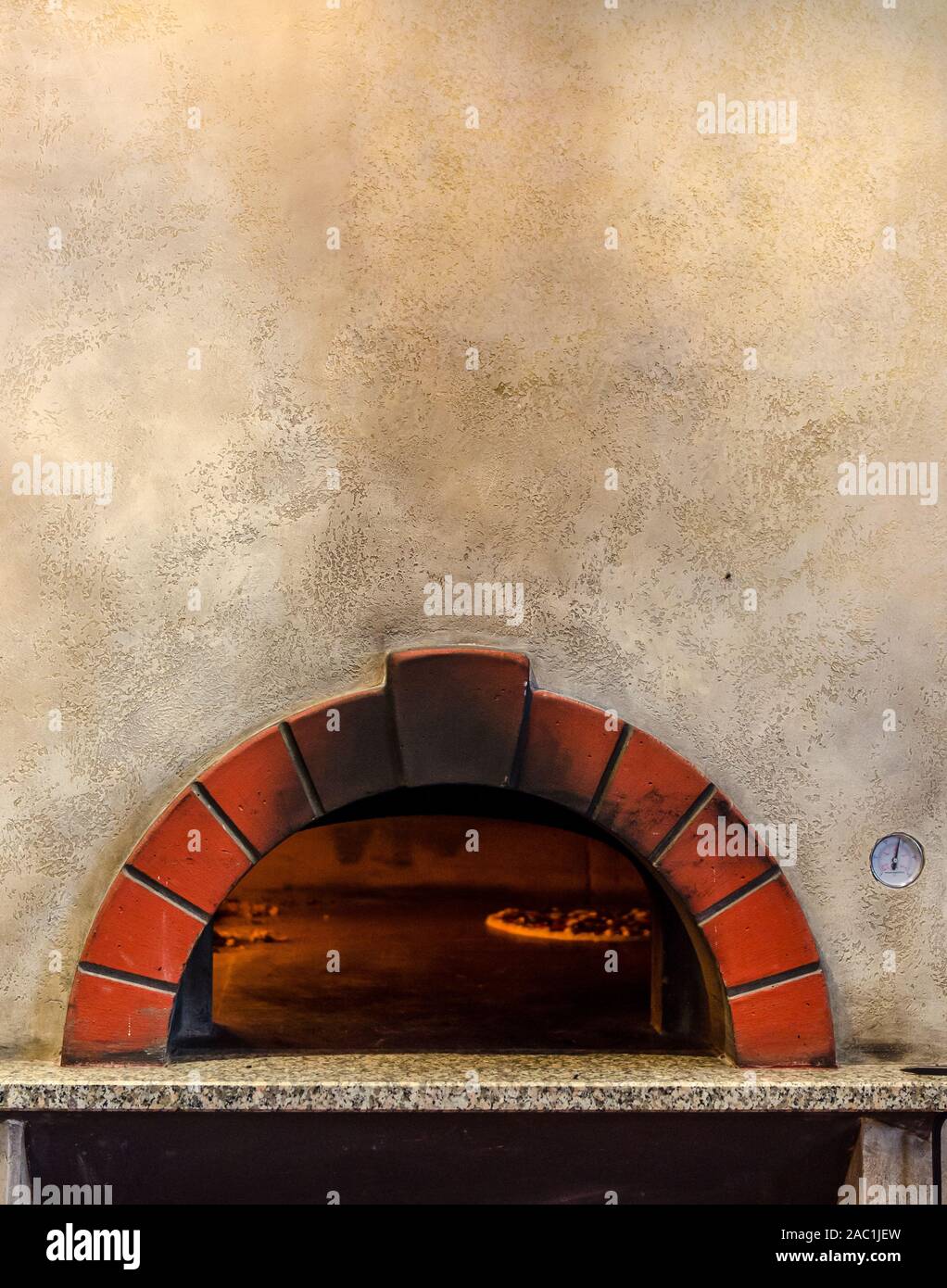 Pizza baking in stone oven - traditional way Stock Photo - Alamy