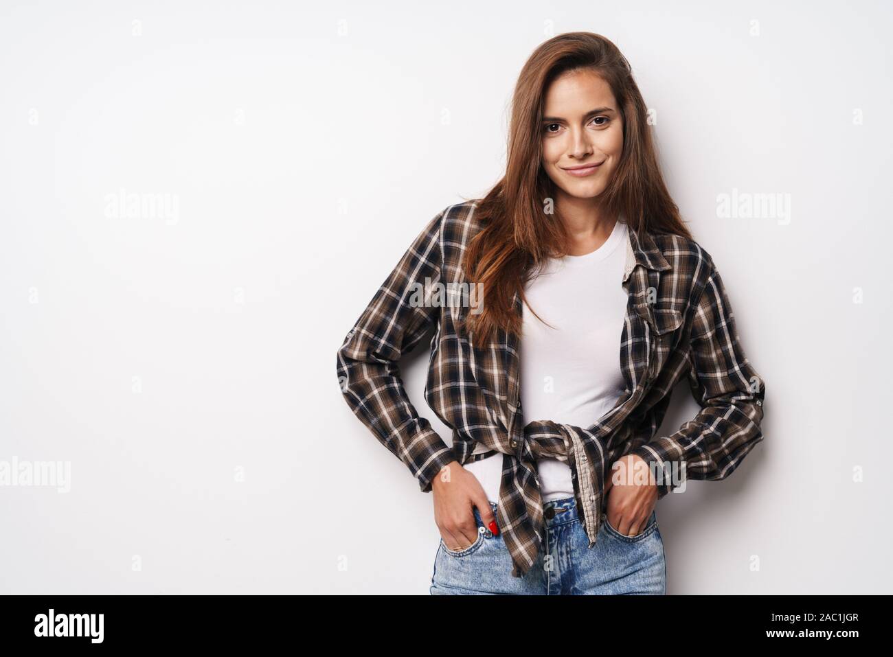 Portrait of a young beautiful girl wearing plaid shirt standing ...