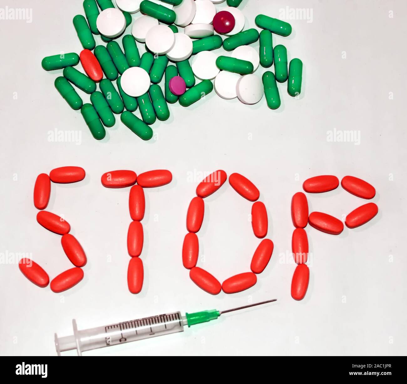 Tablets and capsules are laid out the word Stop. Syringes Stock Photo ...