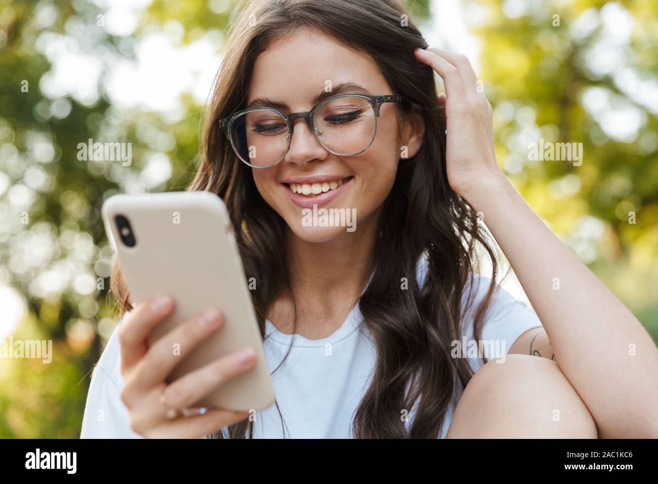 Photo of a optimistic positive young smiling student lady outdoors in ...