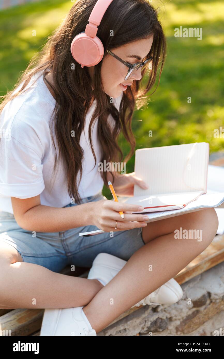 Photo of a positive happy cheerful young student lady outdoors in ...