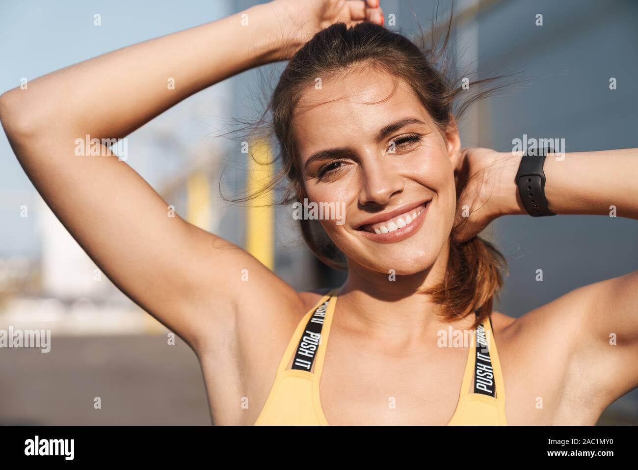Image of pretty woman in sportswear smiling and walking outdoors in ...
