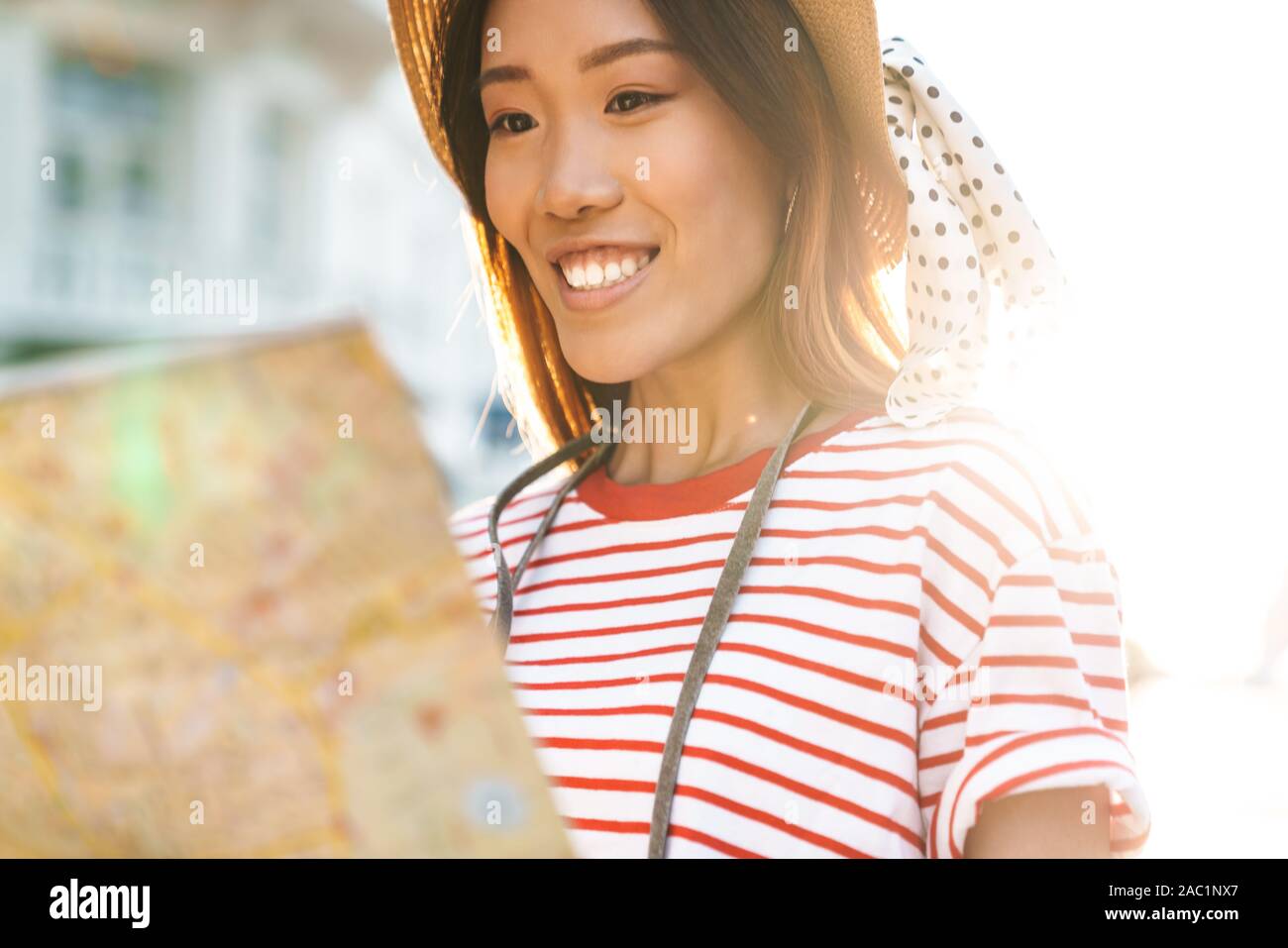 Portrait of young asian tourist woman holding paper map while walking ...