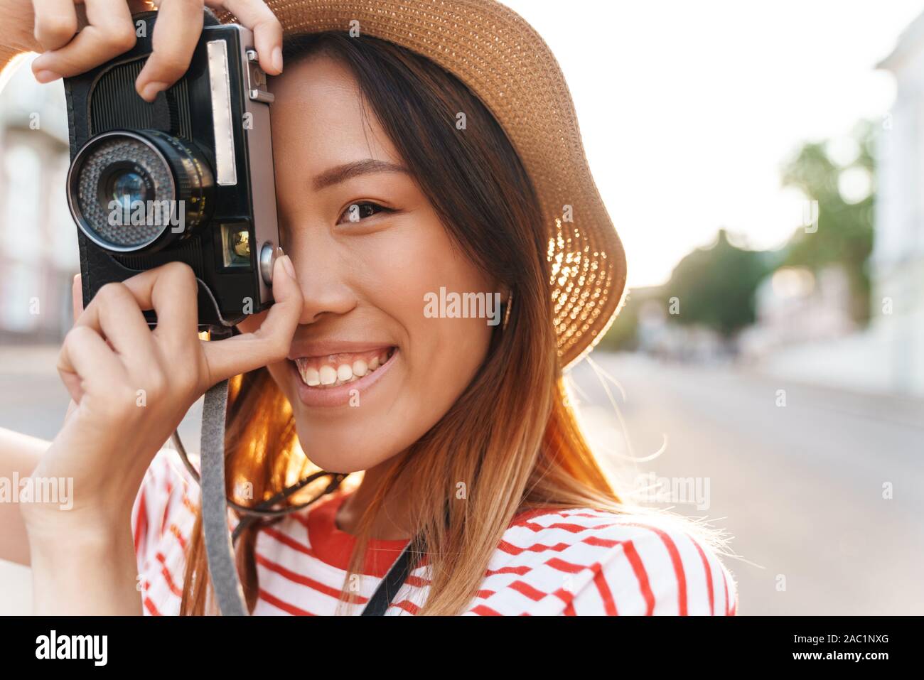 Portrait of happy asian tourist woman photographing on retro camera ...
