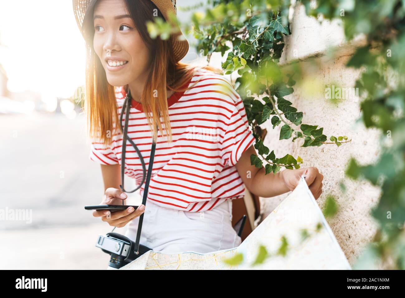 Photo of a young smiling positive beautiful asian woman walking ...