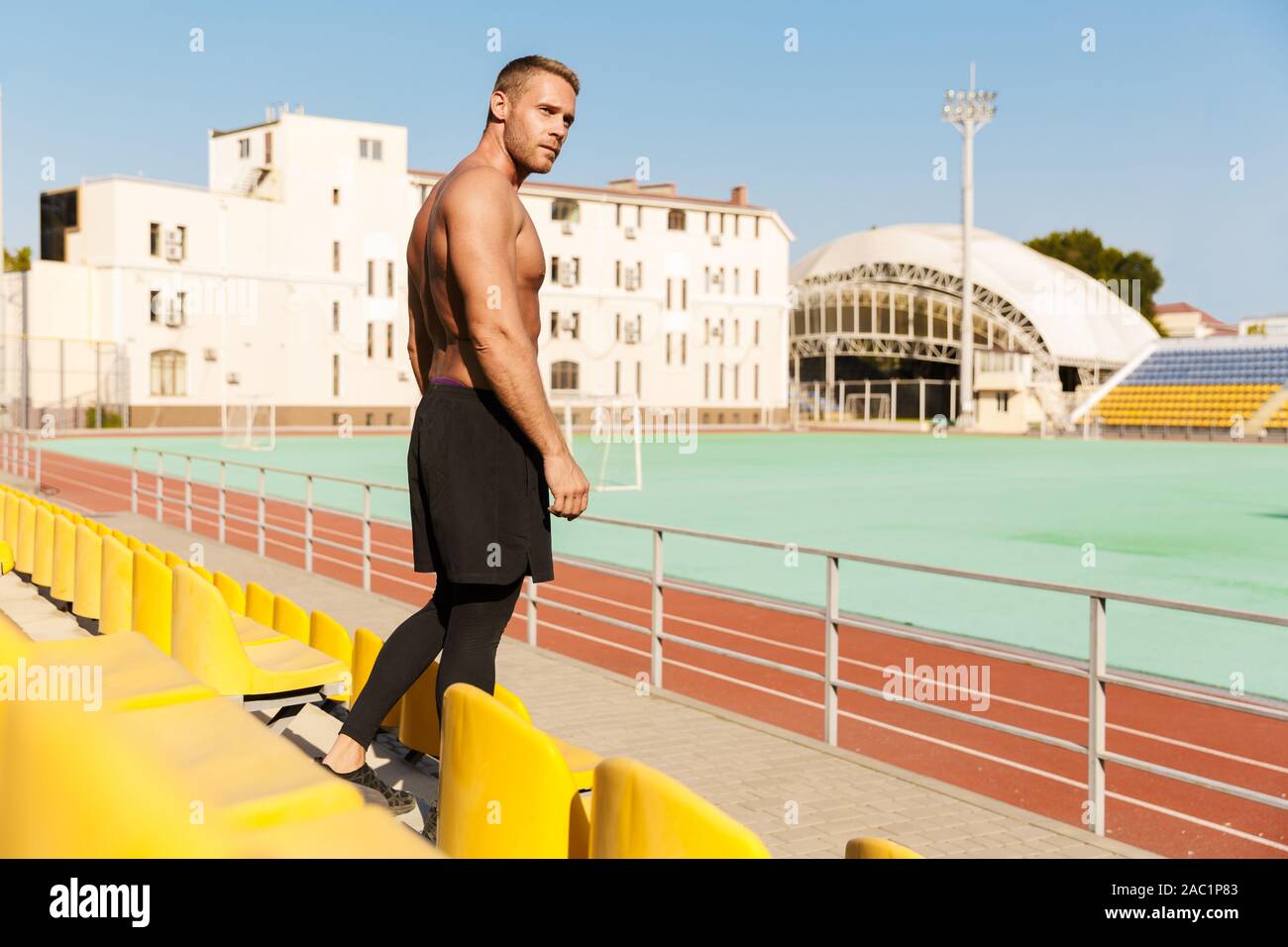 Photo of a strong serious handsome young sports man posing standing at ...