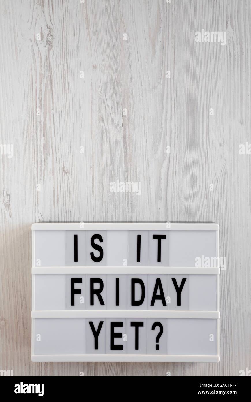'Is it friday yet?' words on a modern board on a white wooden ...