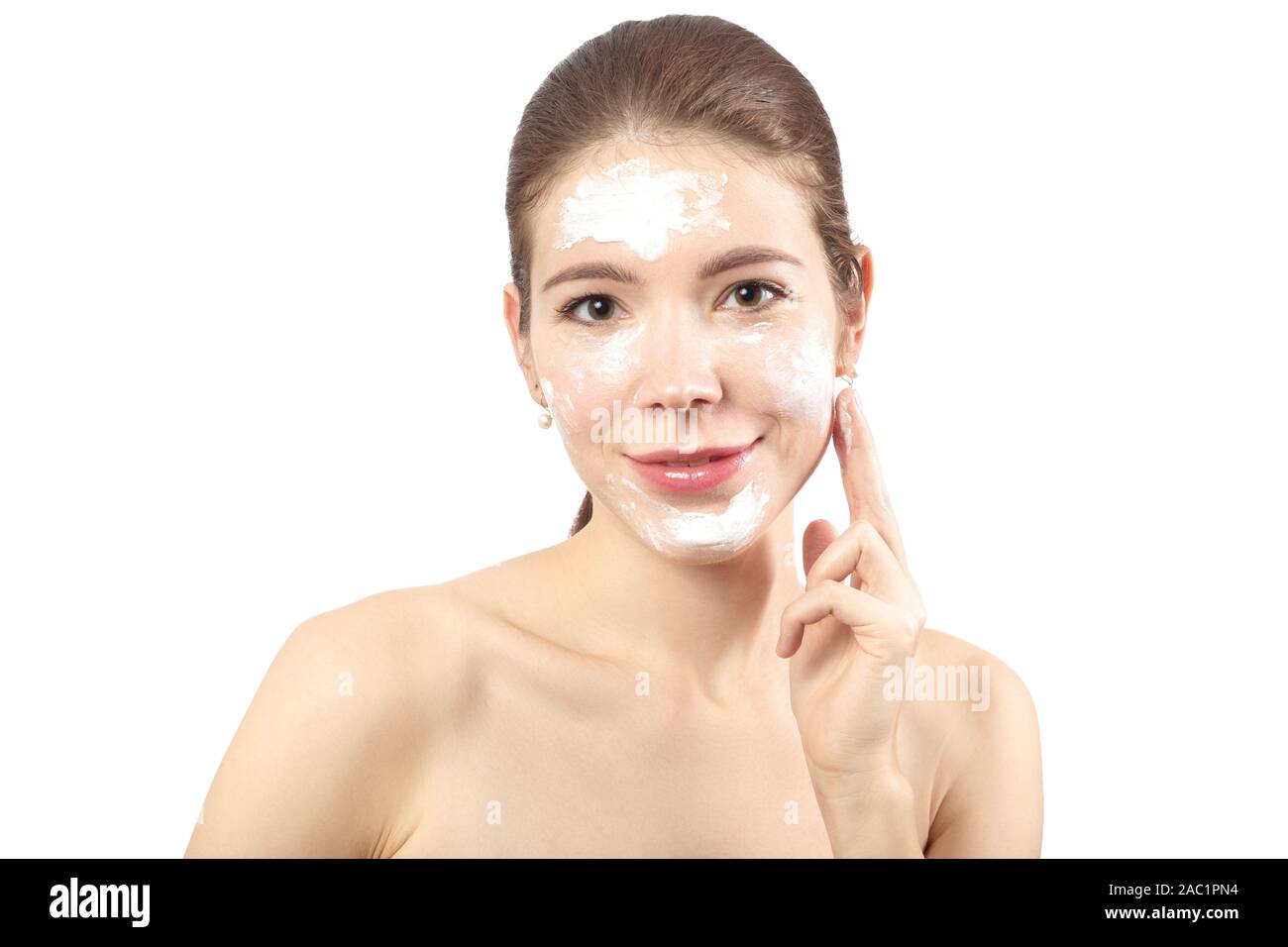 happy young woman applying cream on her face skin, isolated on white ...