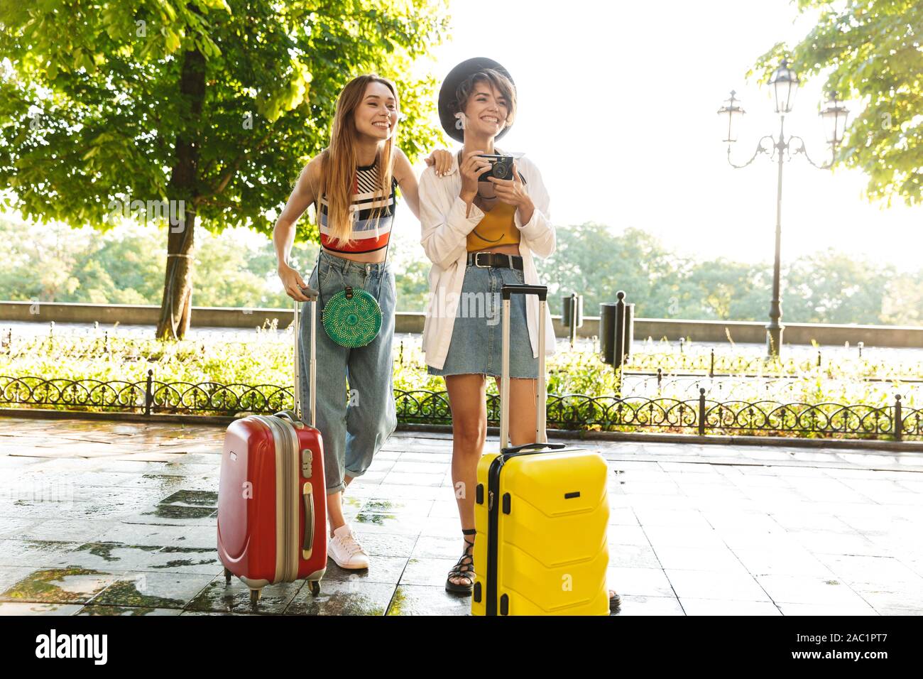 Photo of two smiling attractive women taking photo on retro camera ...