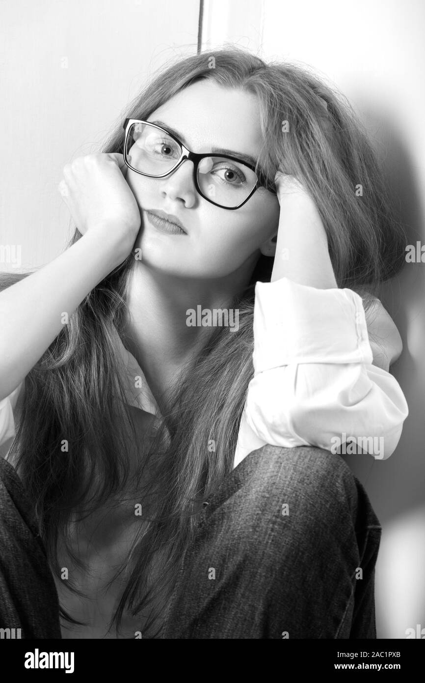 Sad Young Blond Woman In Eyeglasses Sitting Looking At Camera