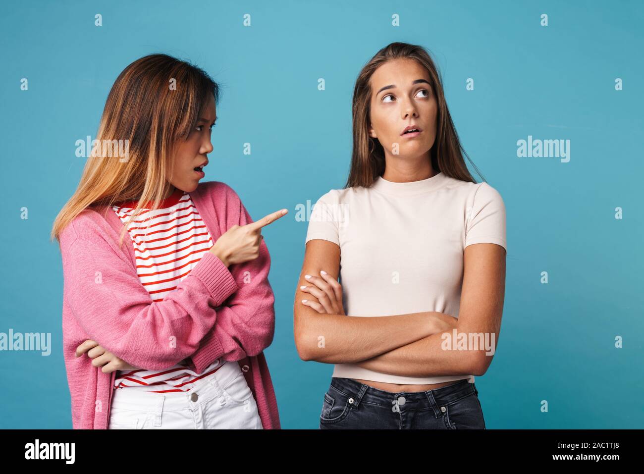 Portrait of multinational annoyed women having quarrel and pointing ...