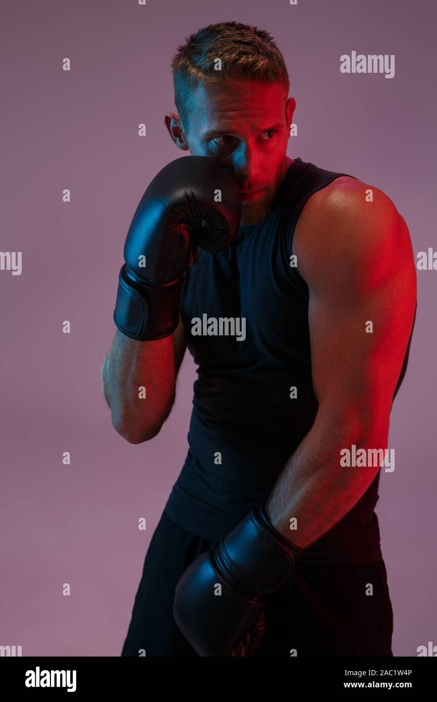 Portrait of a handsome fit muscular boxer man standing isolated over ...