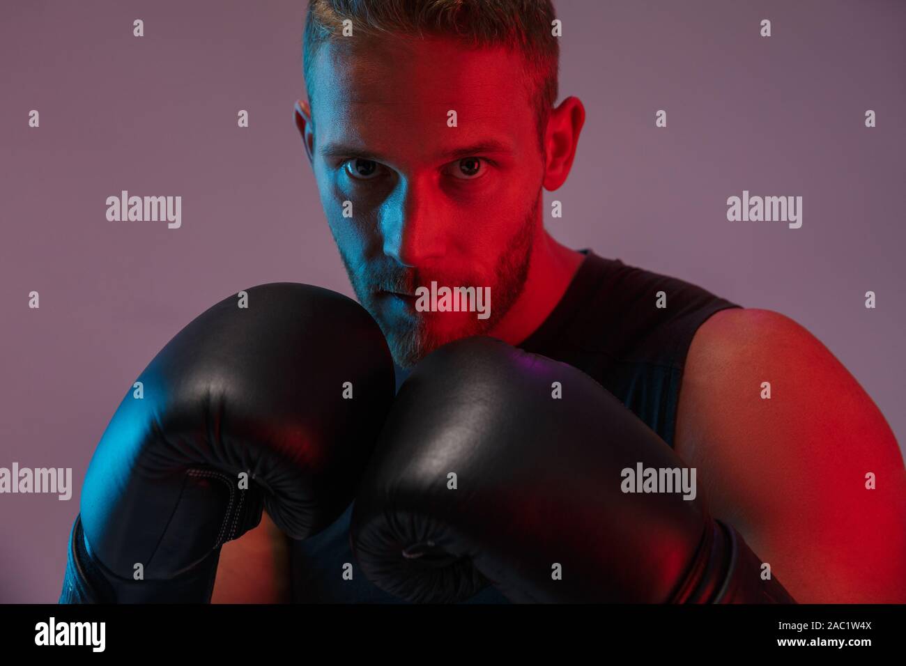 Photo of a concentrated strong young sports man boxer posing isolated ...