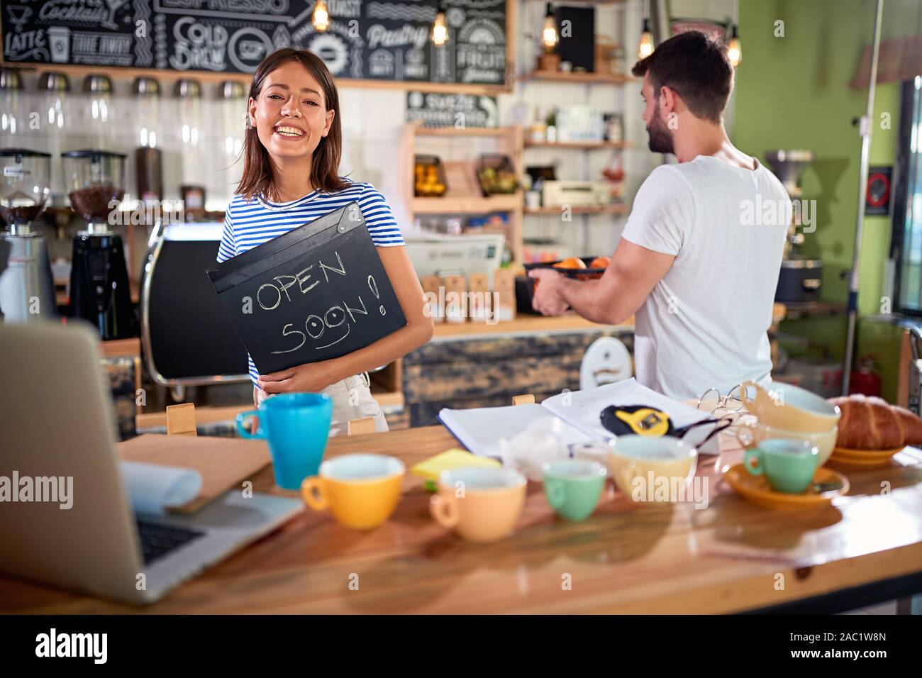 Woman is happy and man is helping her to open cafeteria Stock Photo - Alamy