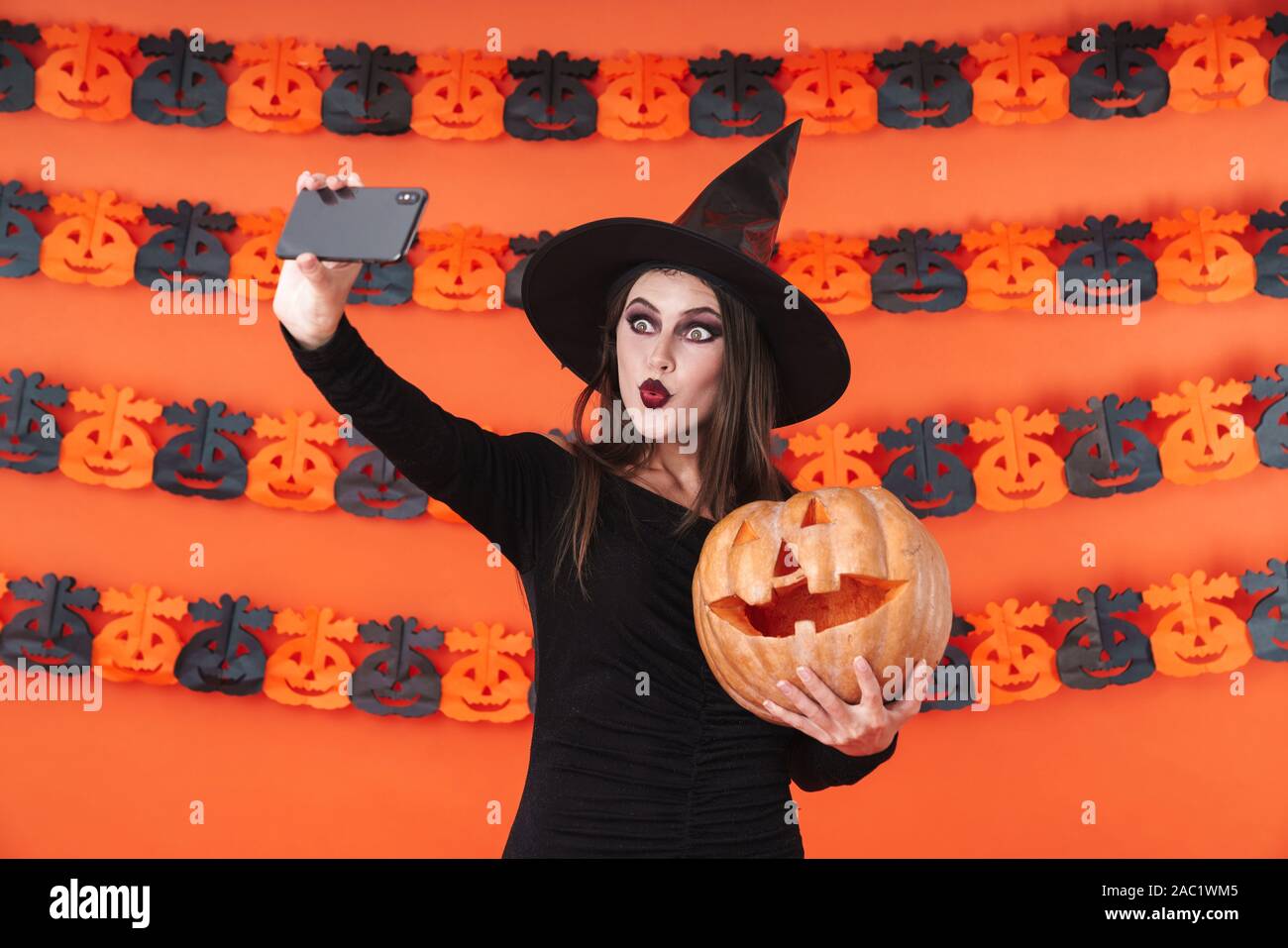 Image of mystic witch girl in black halloween costume taking selfie ...
