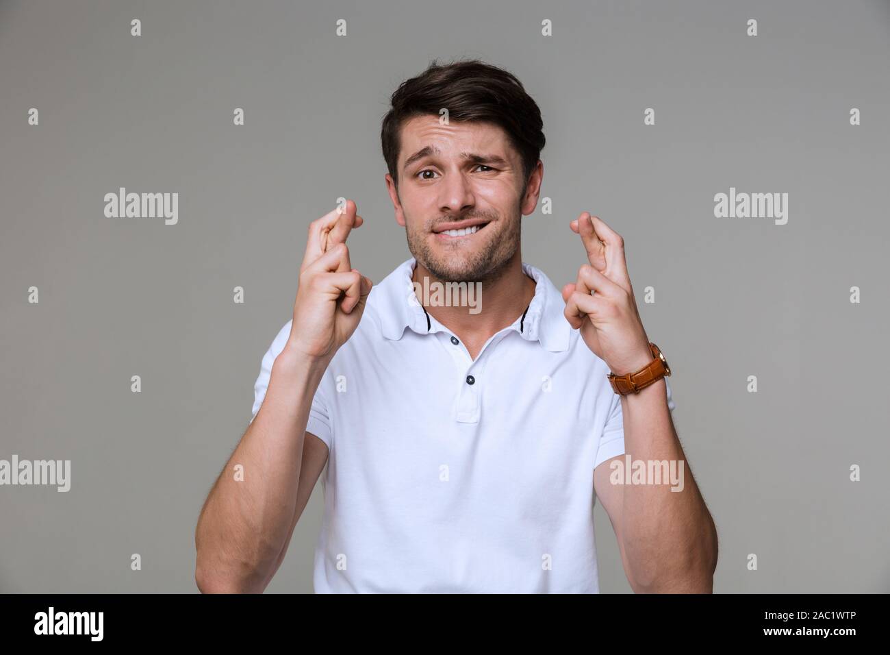 Image of a nervous handsome young man posing isolated over grey wall ...