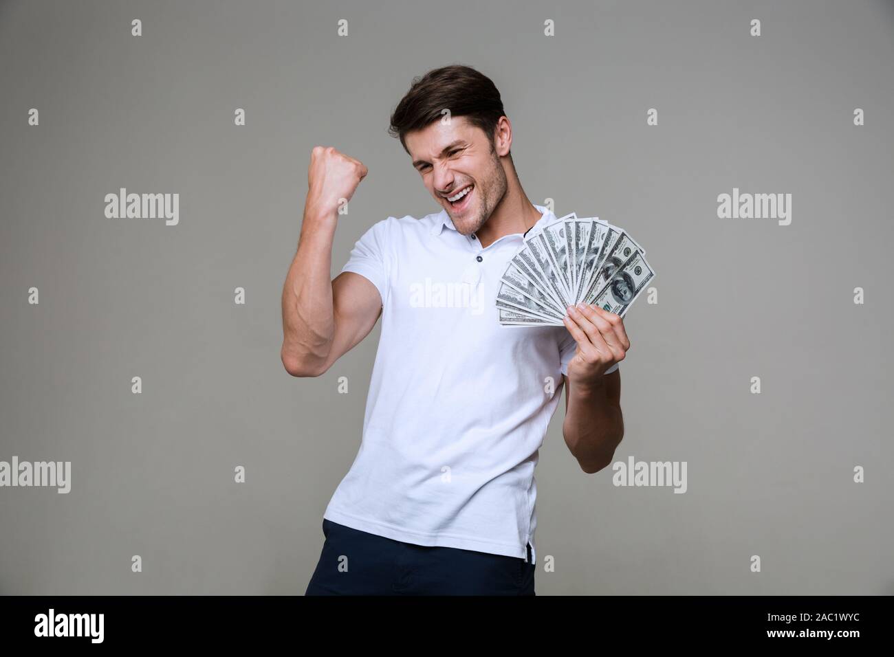 Image of a happy emotional young man posing isolated over grey wall ...