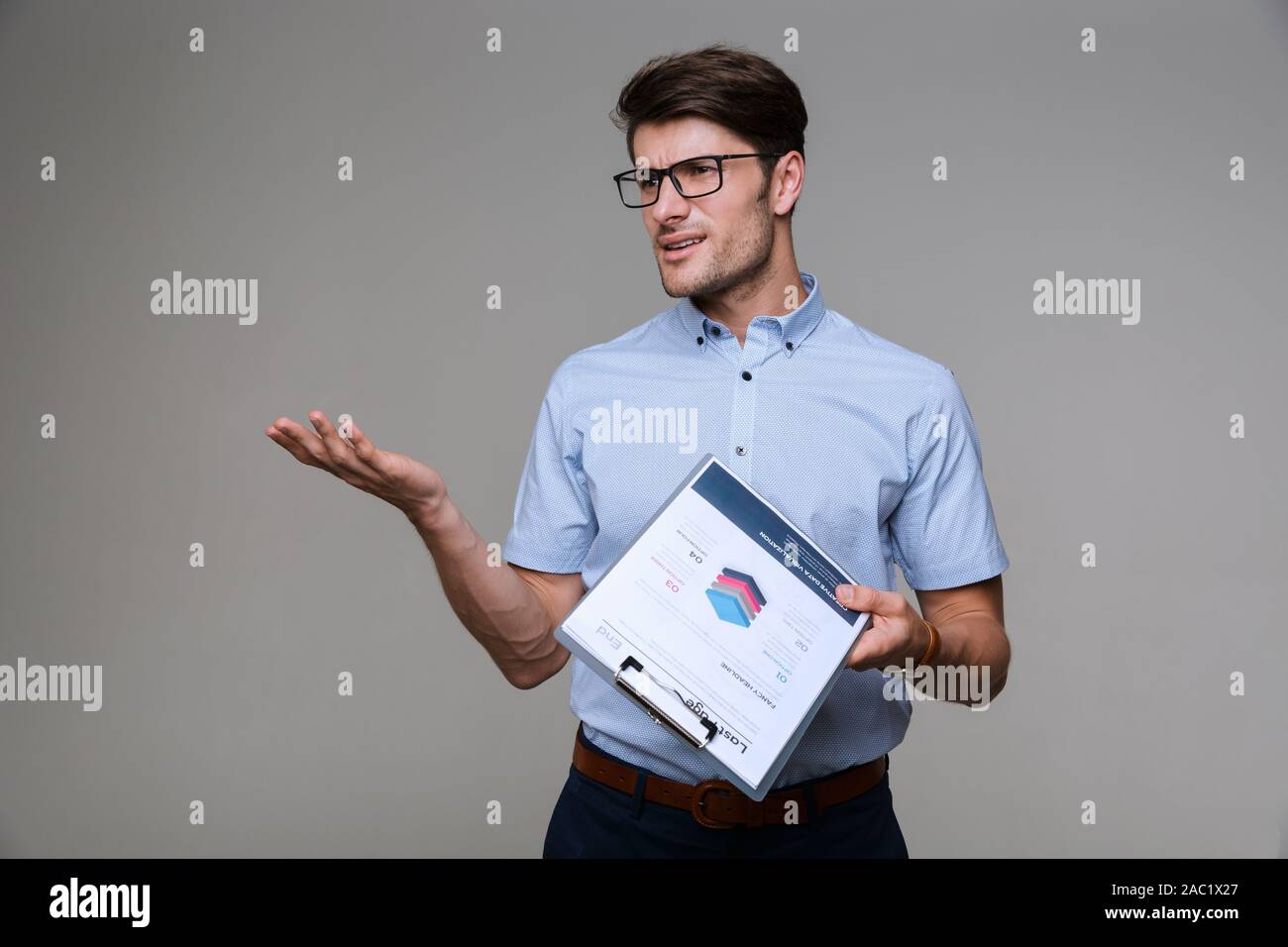Photo of a confused displeased business man posing isolated over grey ...