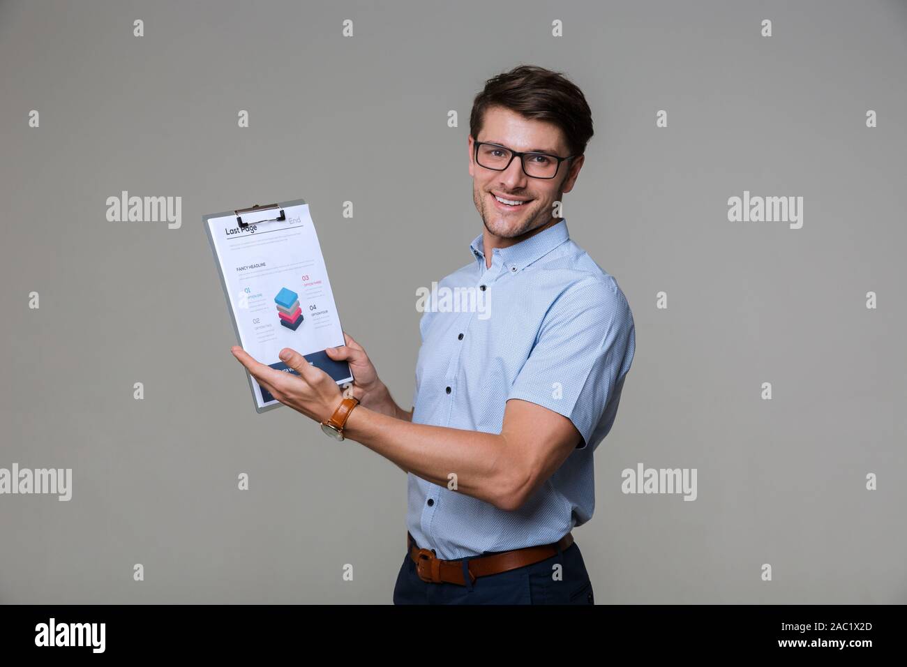 Image of a cheery pleased business man posing isolated over grey wall ...