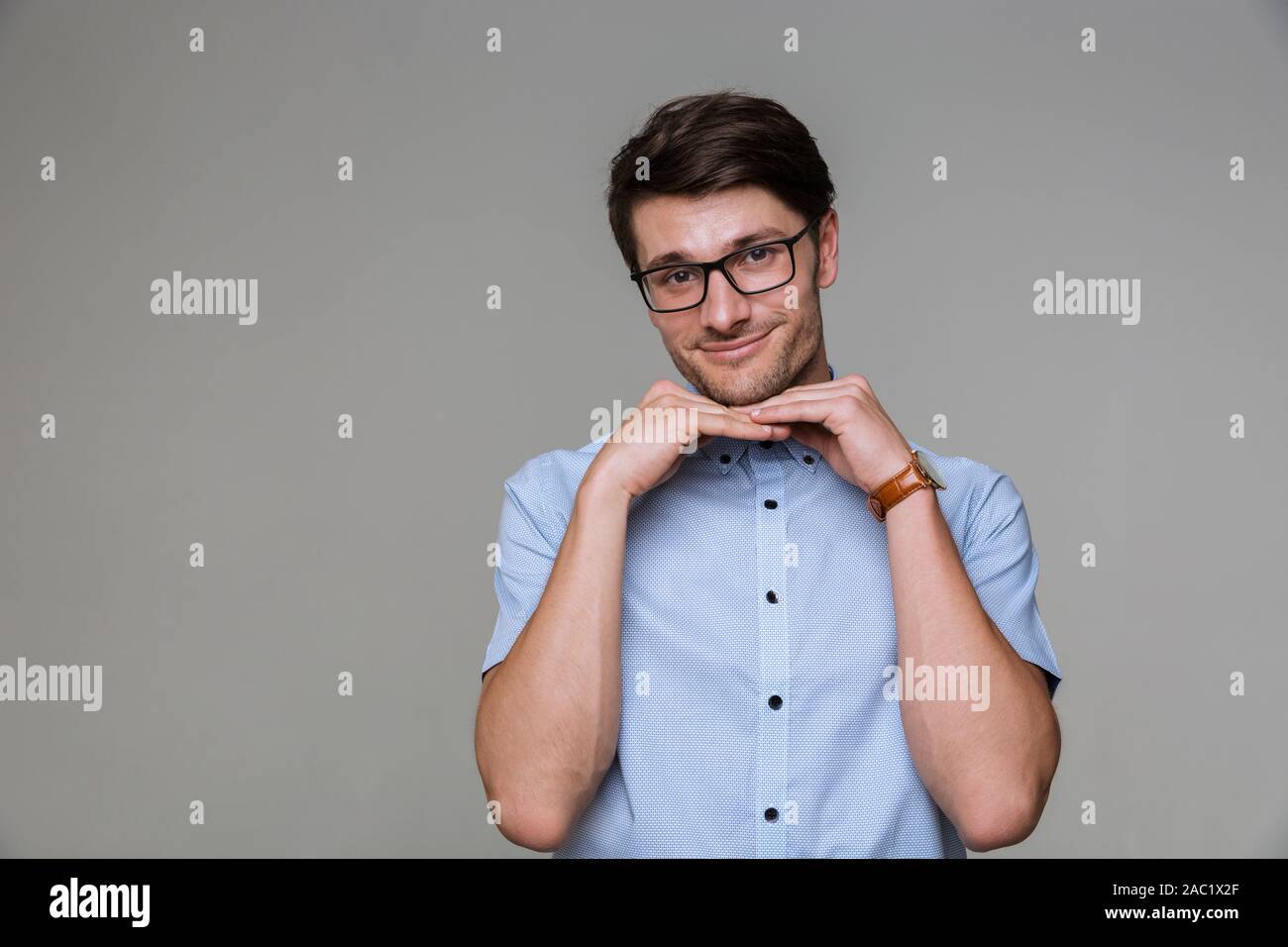 Photo of smiling cute optimistic business man isolated over grey wall ...