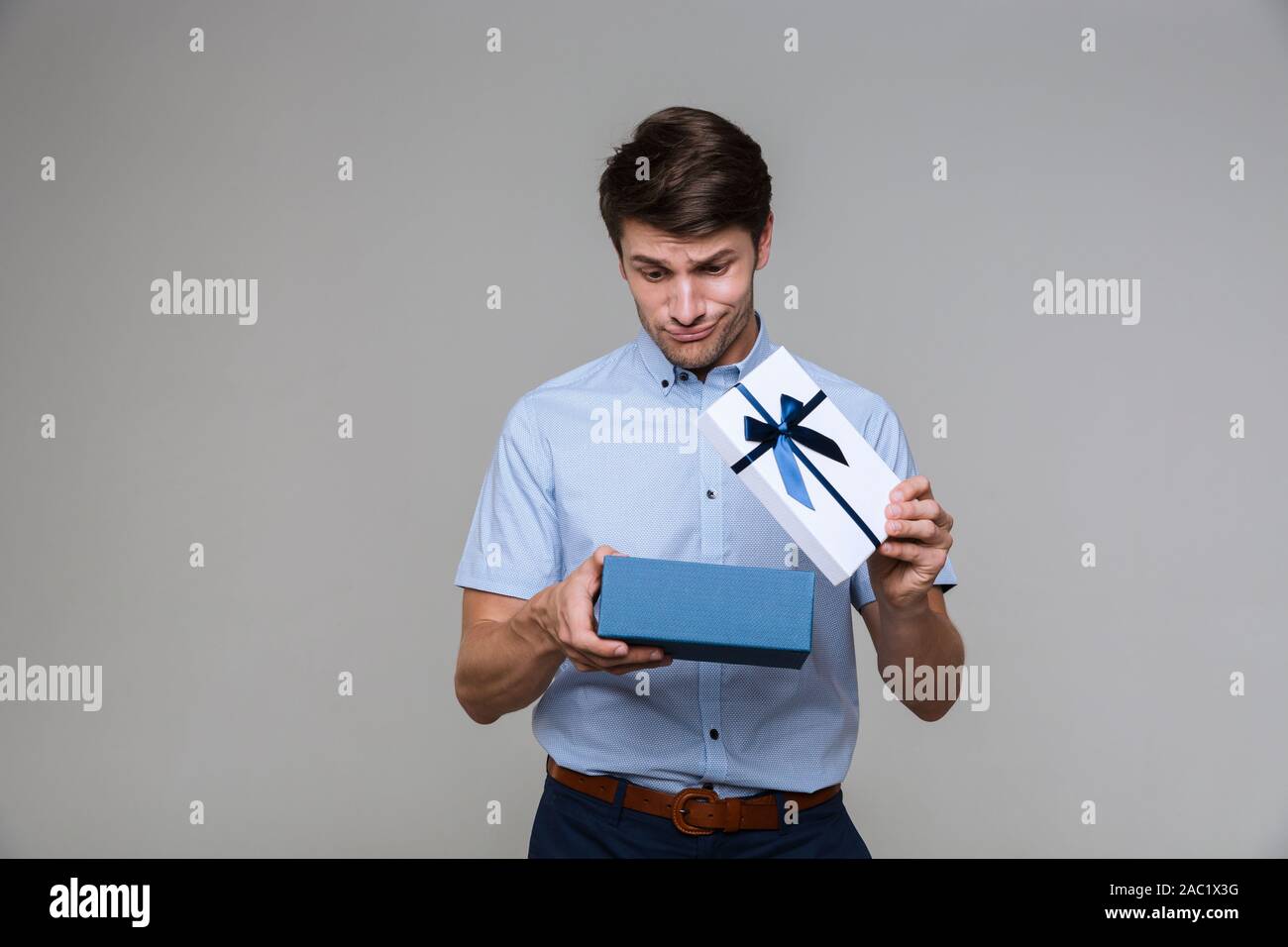 Image of confused sad business man isolated over grey wall background ...