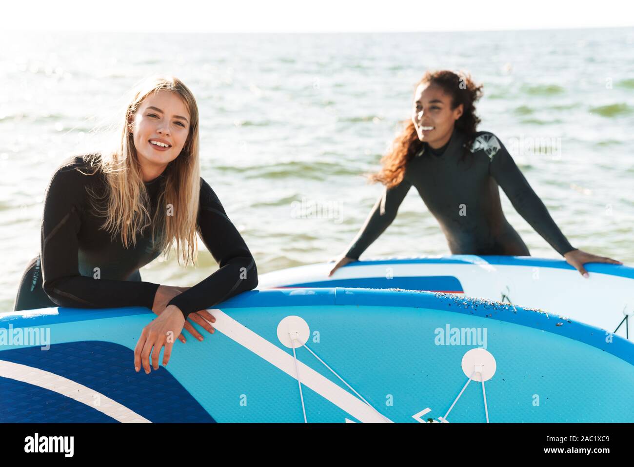 Image of a cheery happy beautiful young two women with kayaks outdoors ...