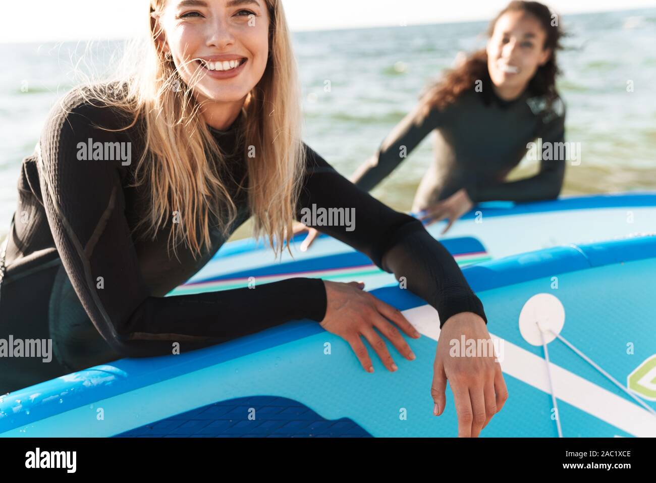 Image of a cheery happy beautiful young two women with kayaks outdoors ...