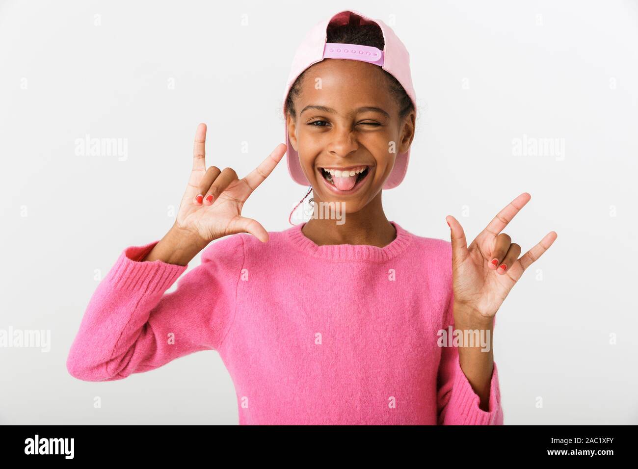 Image of joyful african american girl in pink cap grimacing and ...