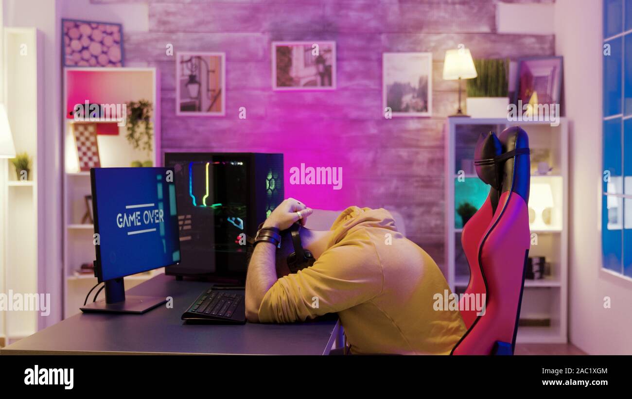 Successful man playing online video games on his computer. Professional ...