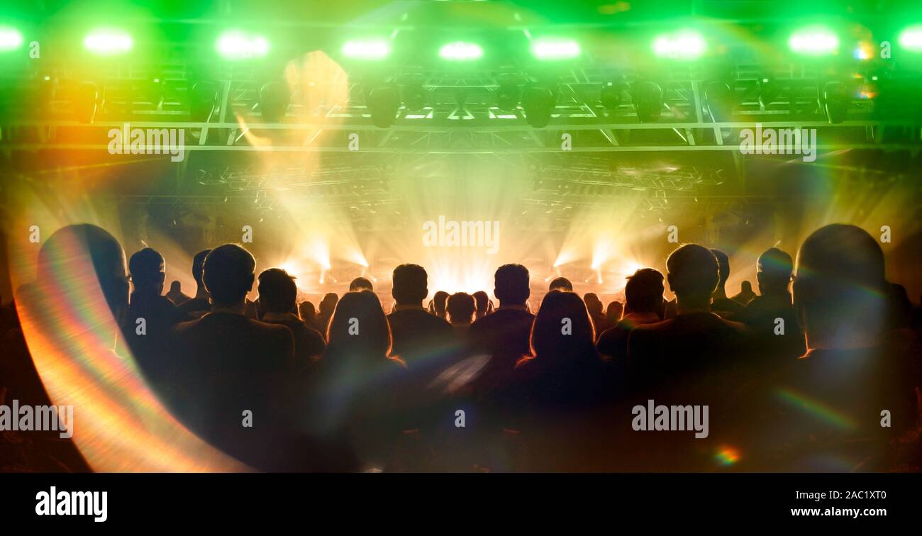 Photo of a concert hall with people silhouettes clapping in front of a ...