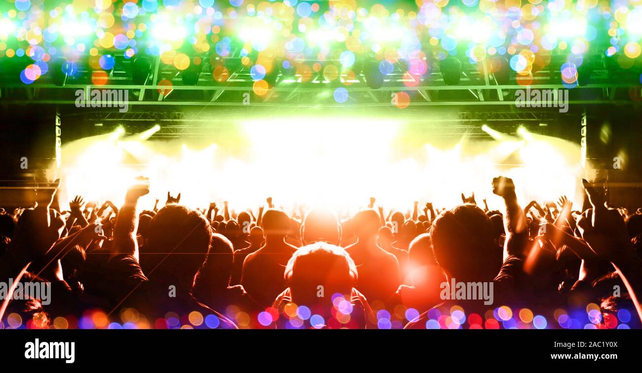 Photo of a concert hall with people silhouettes clapping in front of a ...