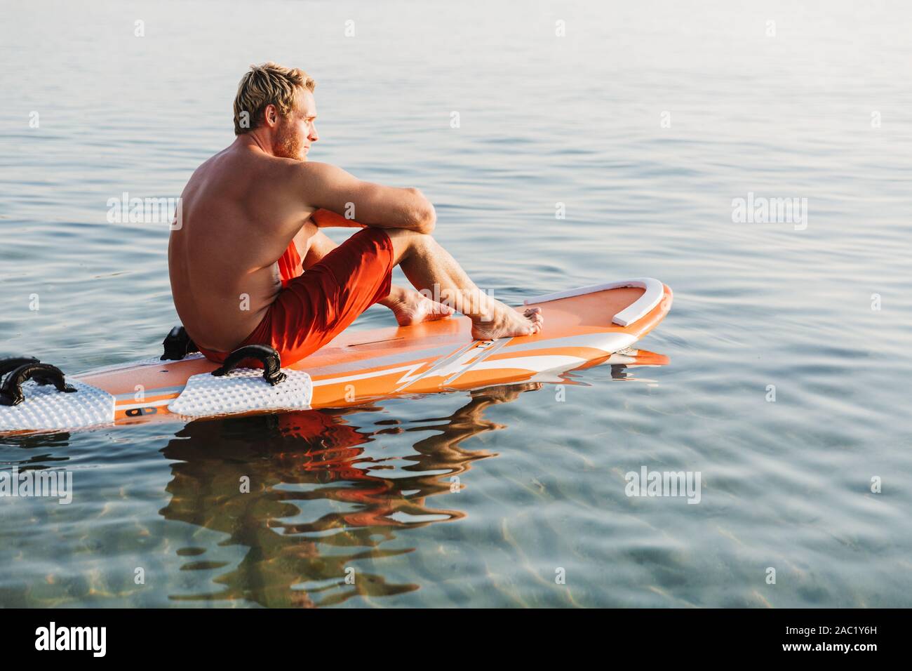 Photo of a strong concentrated handsome young man surfer with surfing ...