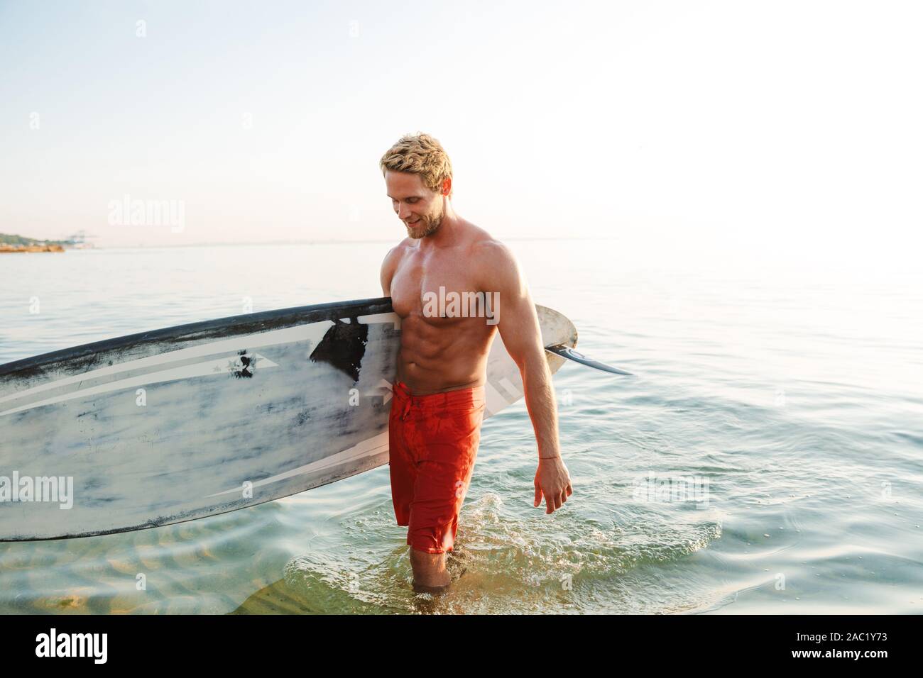 Image of attractive handsome young man surfer with surfing desk at the ...