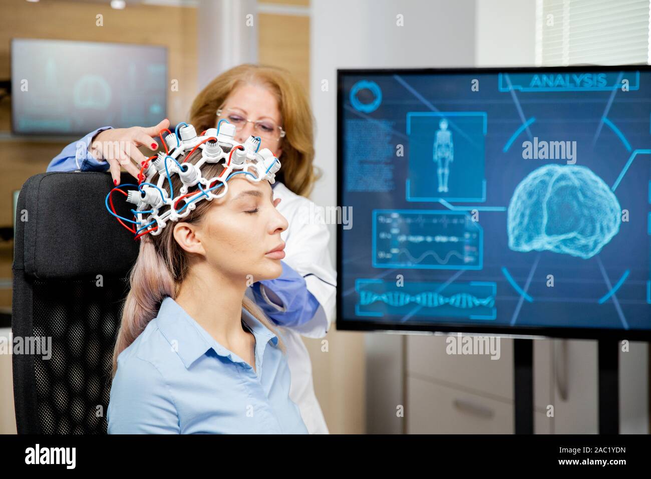 Doctor arranging scanning device on head of a female patient Stock ...