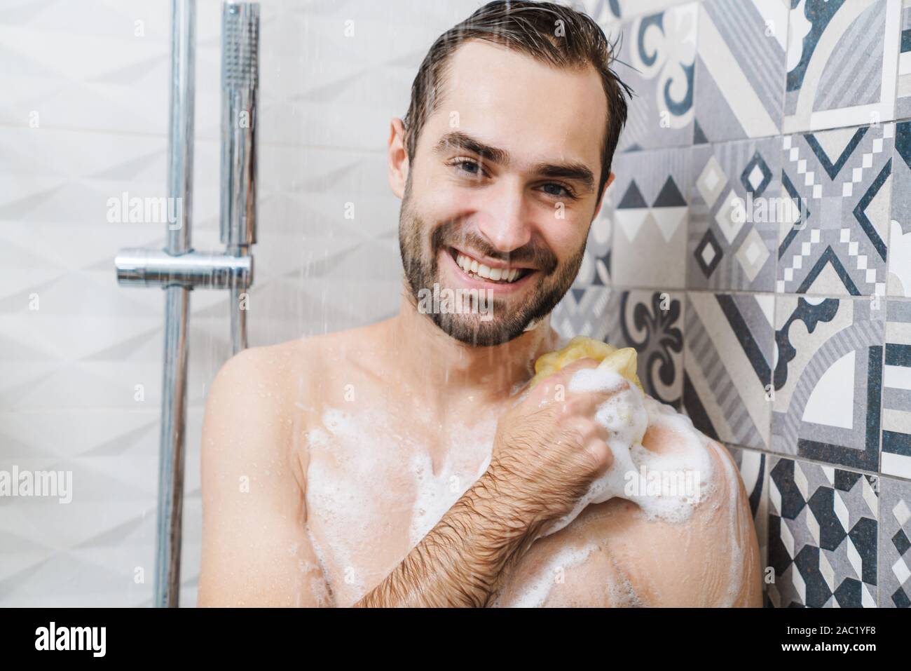 Attractive young smiling man washing while standing in the shower Stock ...