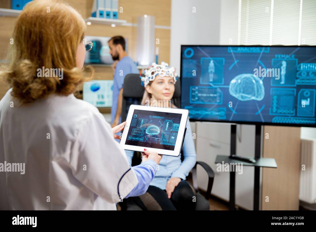 Doctor who looks at the evolution of the patient's brain on the tablet ...